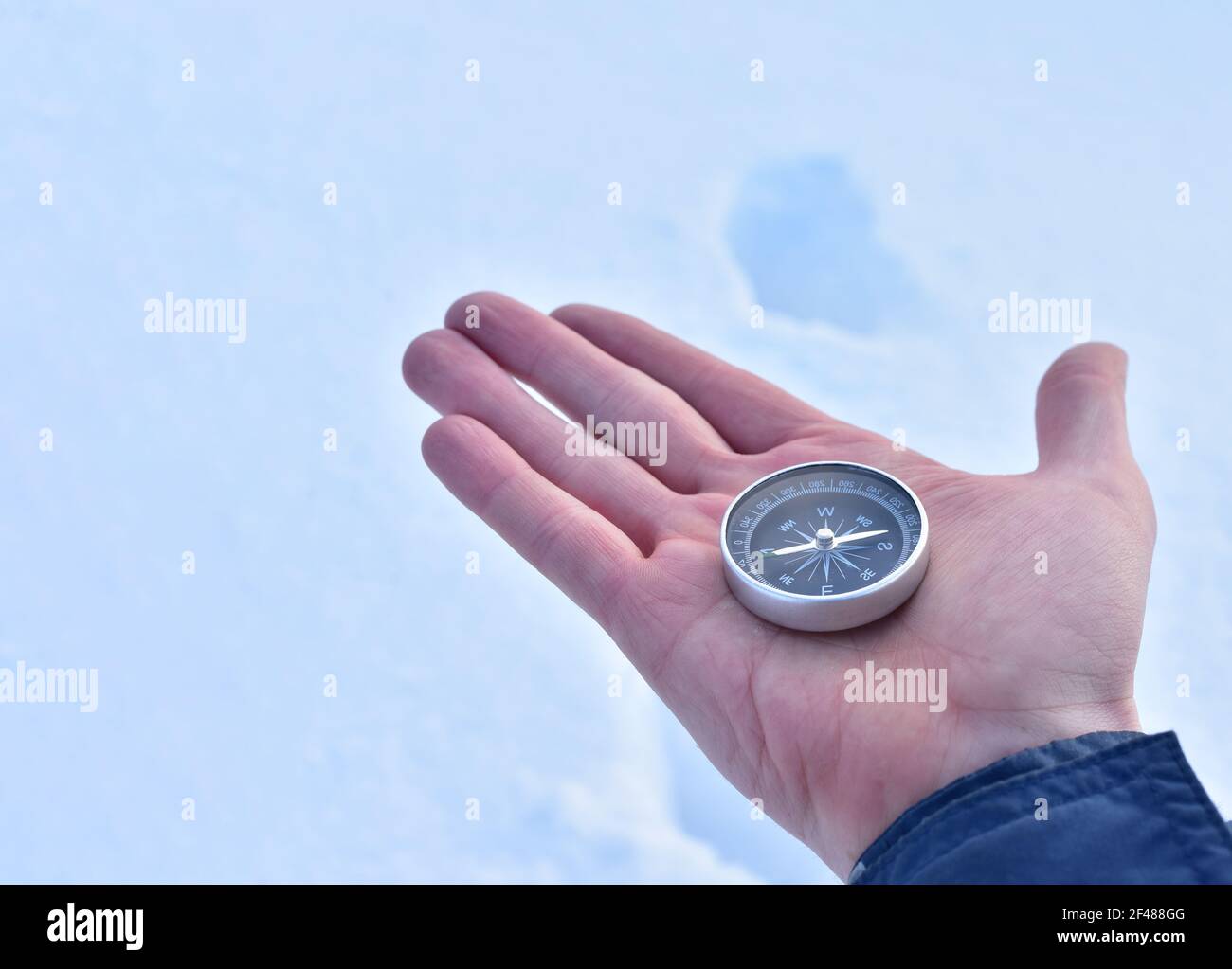 Compass in hand on snow background. Orientation on terrain in forest ...