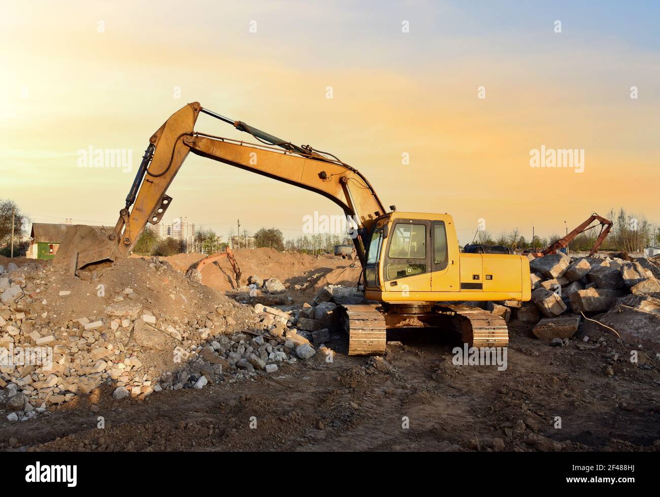Excavator on demolition the old buildingon sunset background. Backhoe ...