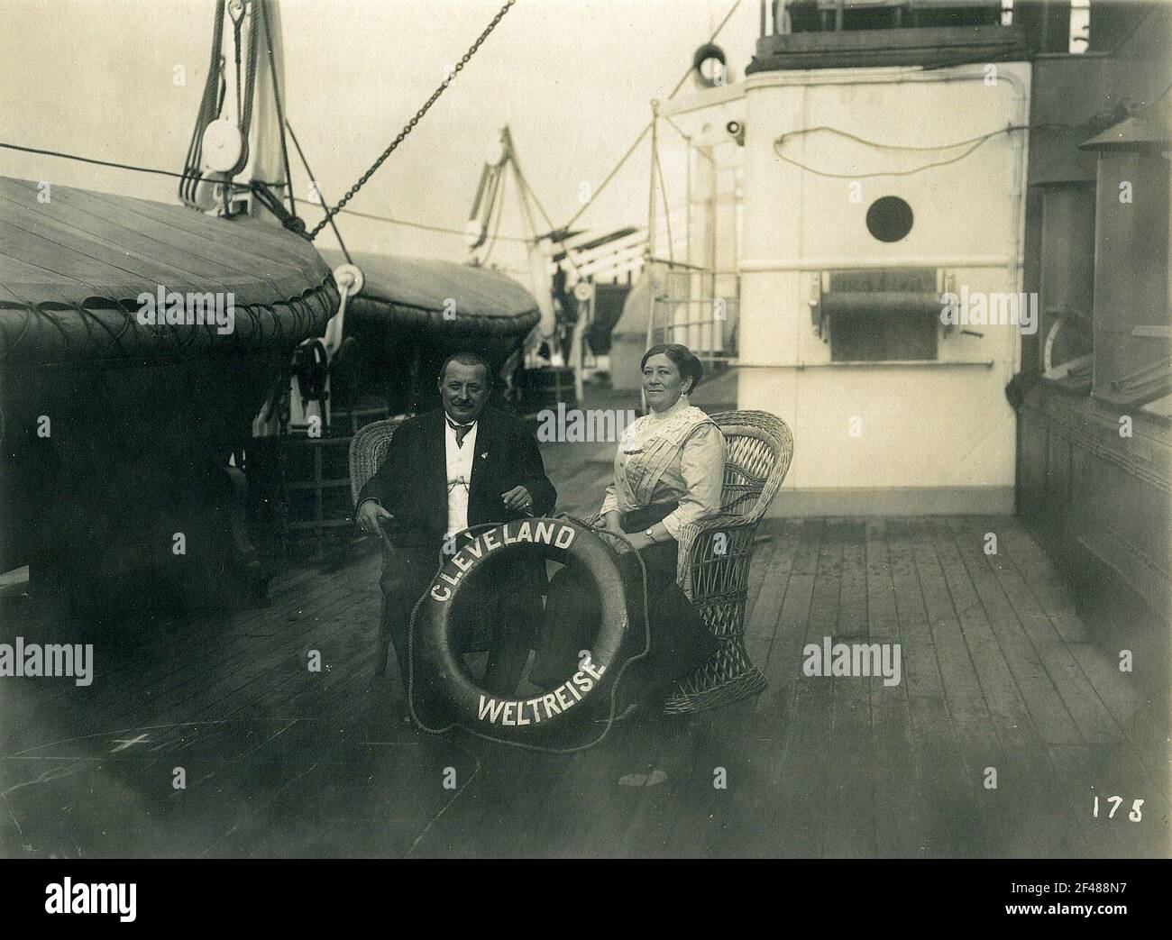 Tourist couple in wicker chairs on deck of the high-sea passenger ...
