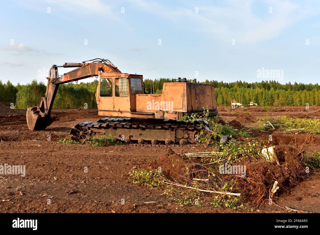 Excavator digging drainage ditch in peat extraction site. Drainage of ...
