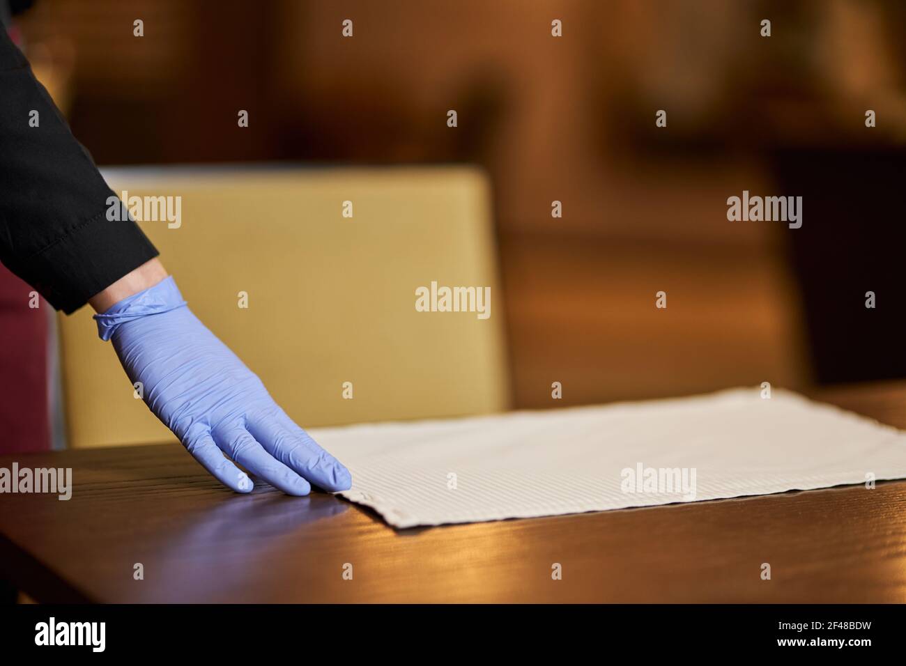 Restaurant staff using gloves for setting up tables Stock Photo - Alamy