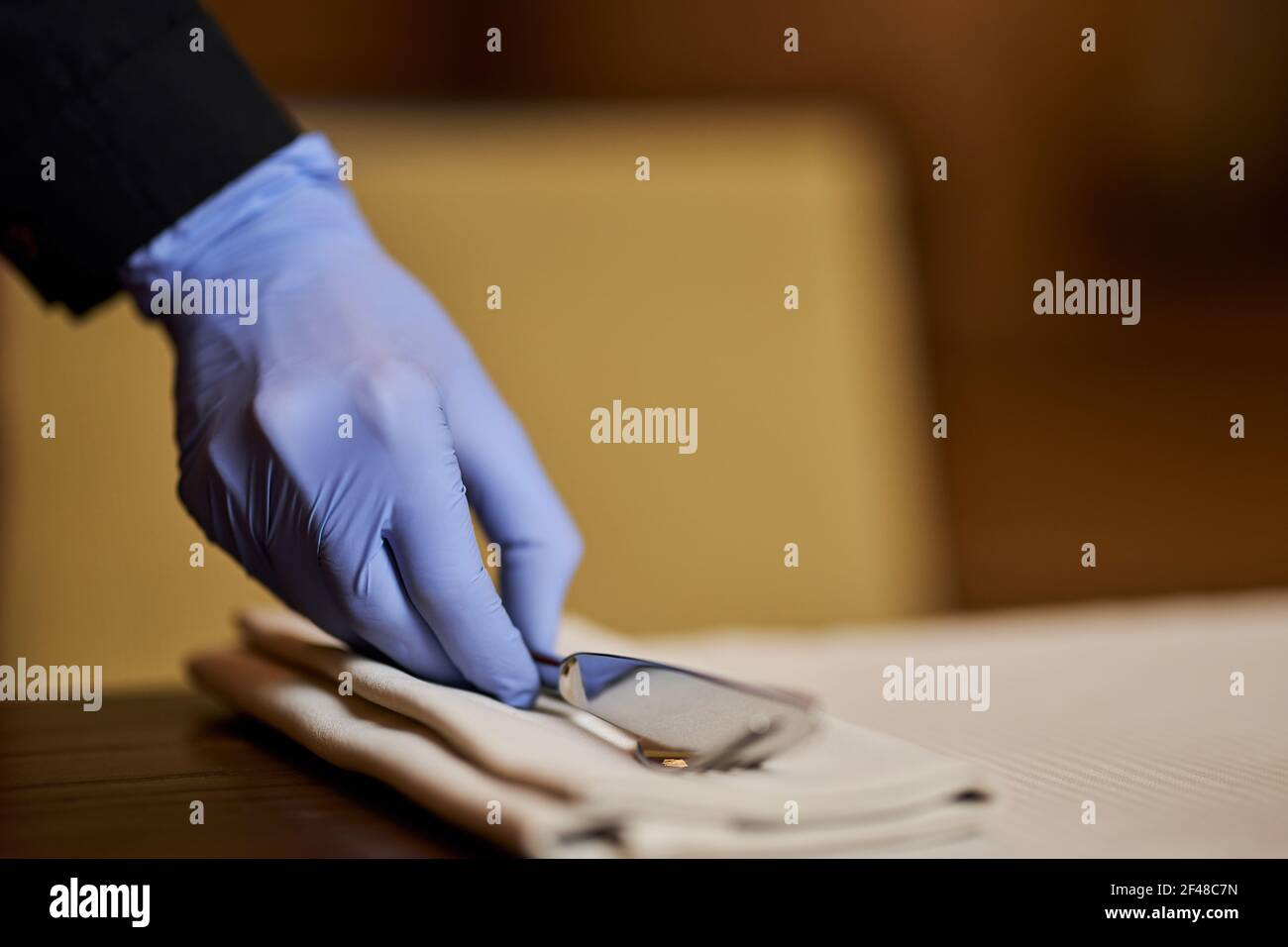 Setting tables up only with disposable gloves on Stock Photo - Alamy