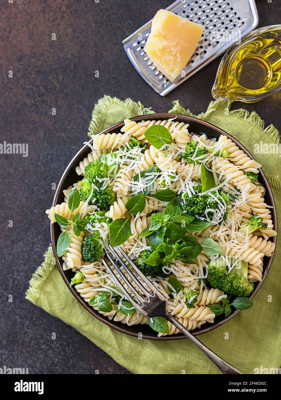 Fusilli with with broccoli, basil and parmesan cheese on a dark ...