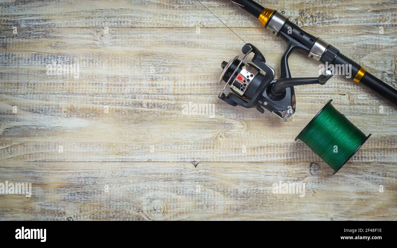 Fishing tackle, many colorful baits with a fishing rod on a wooden pier ...