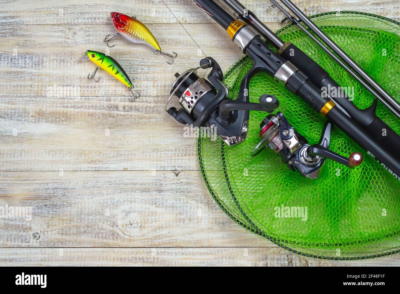 Fishing tackle, many colorful baits with a fishing rod on a wooden pier ...