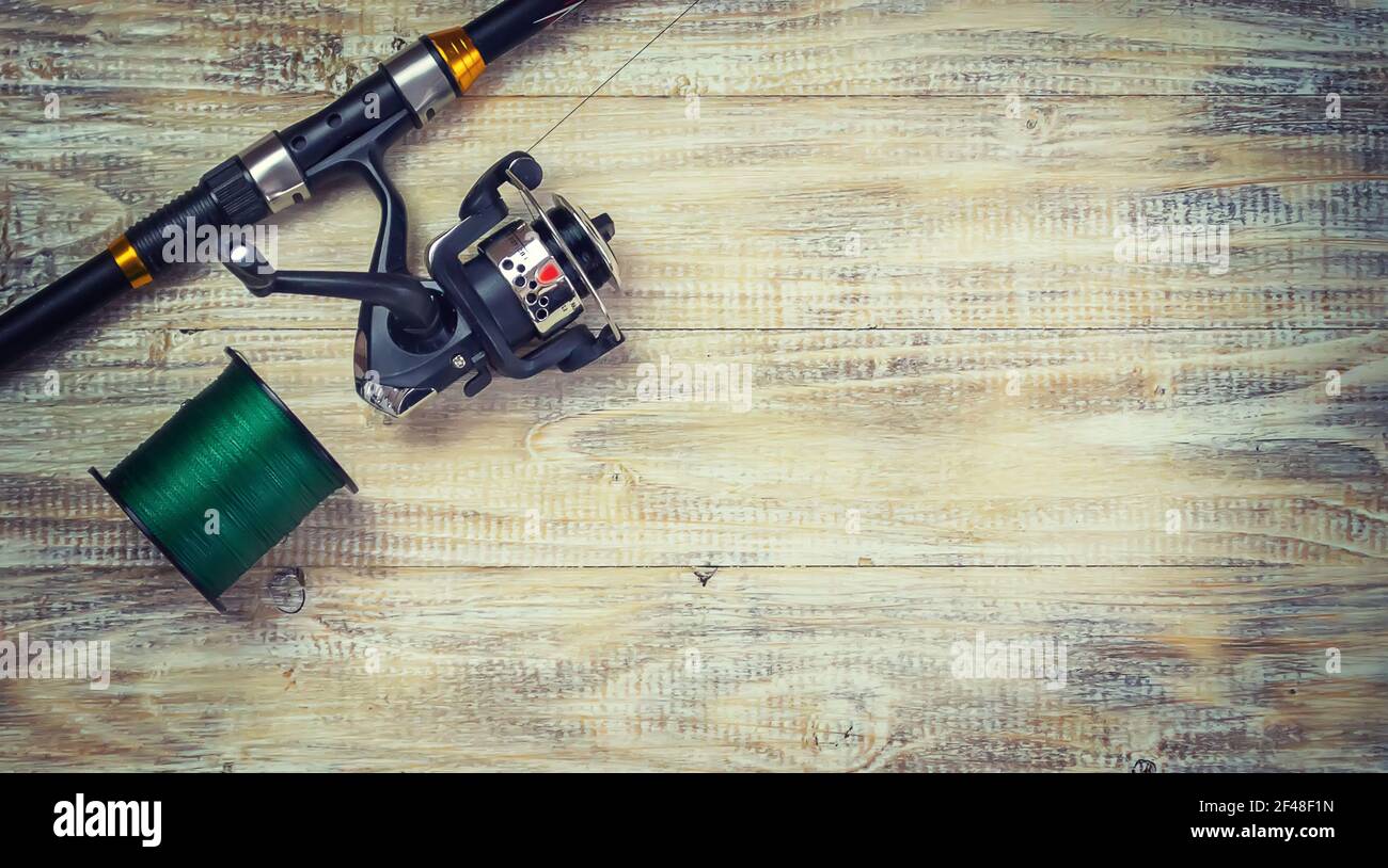 Fishing tackle, many colorful baits with a fishing rod on a wooden pier ...
