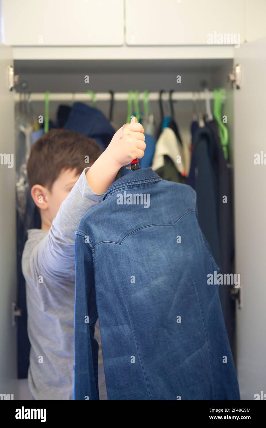 Baby Choosing Clothes in Wardrobe at Home Stock Photo - Alamy