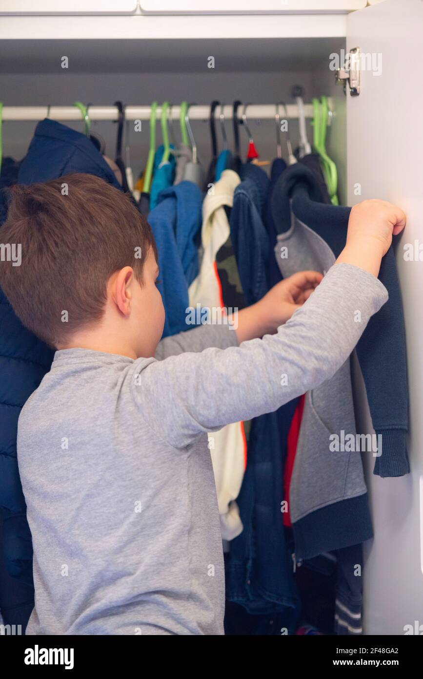 Baby Choosing Clothes in Wardrobe at Home Stock Photo - Alamy