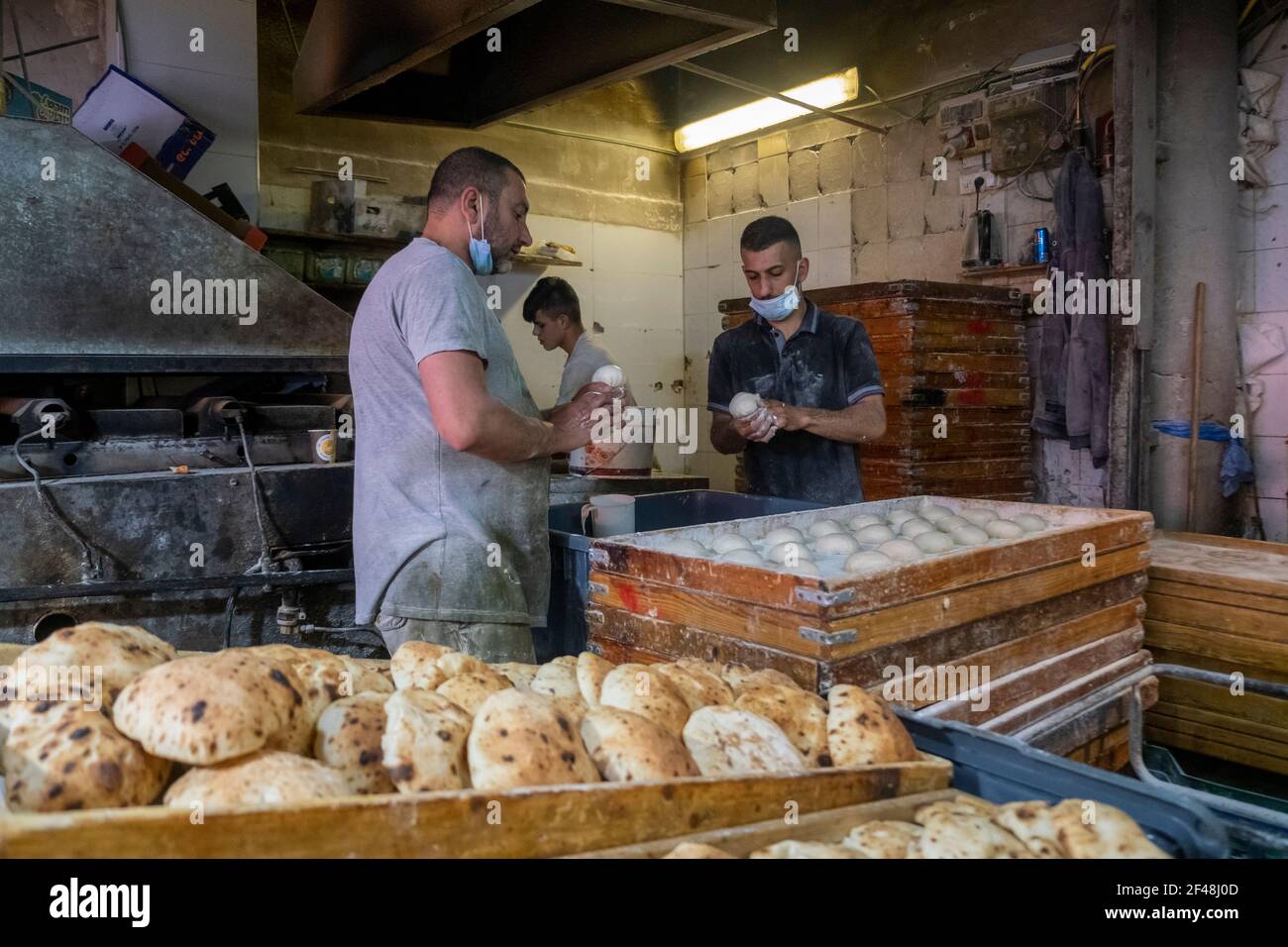 Israeli Arab men baking Pita bread in a bakery in Mahane or Machane ...
