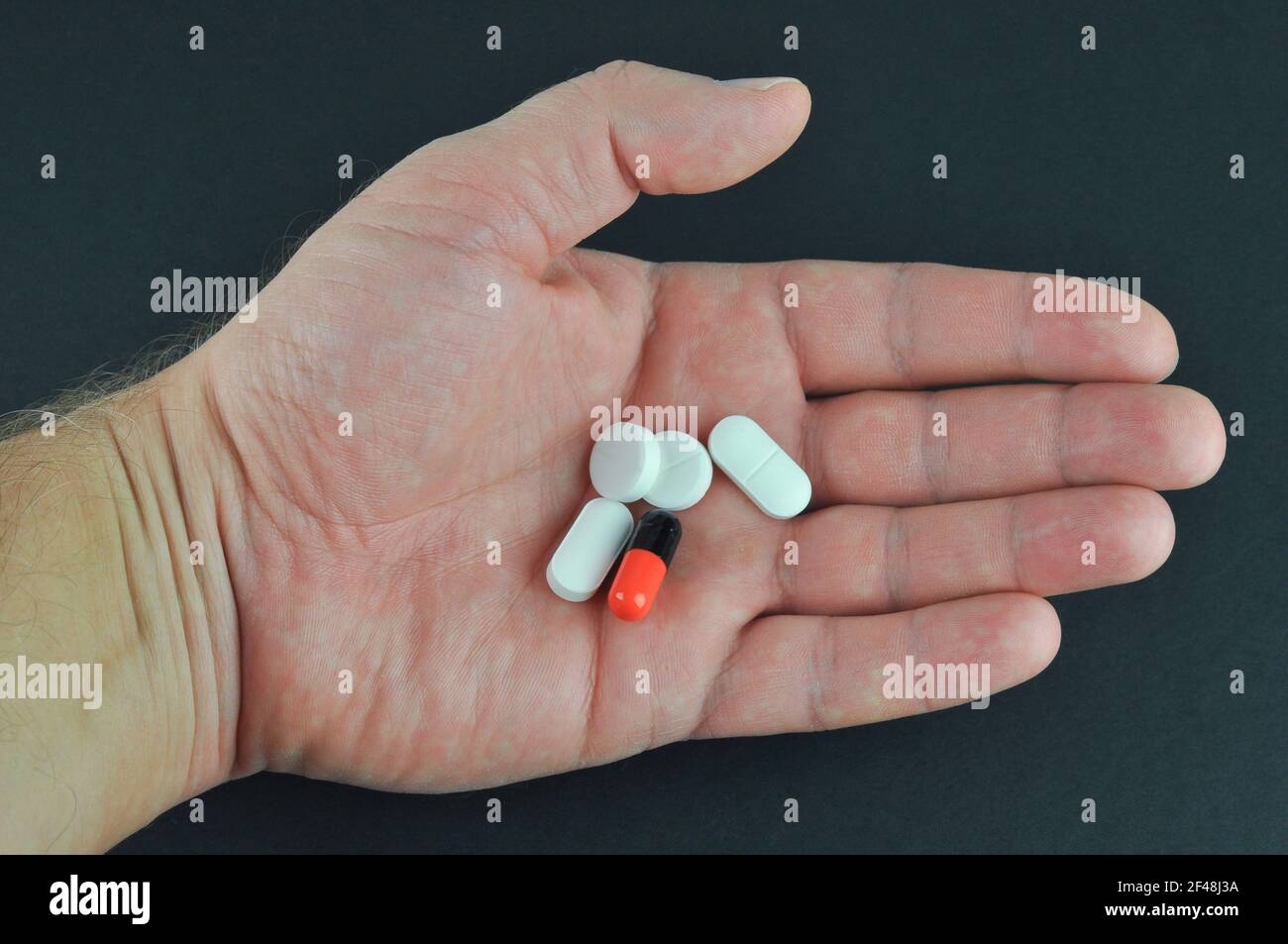 Pills in hand on dark grey background. Concept of Taking Your ...