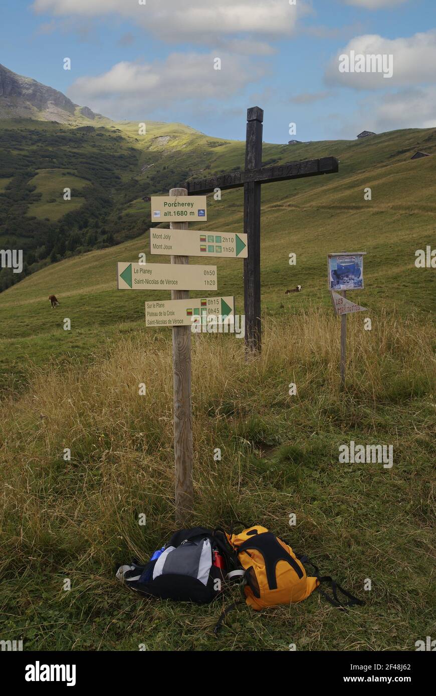 The signs with hiking routes and a wooden cross in the mountains of ...