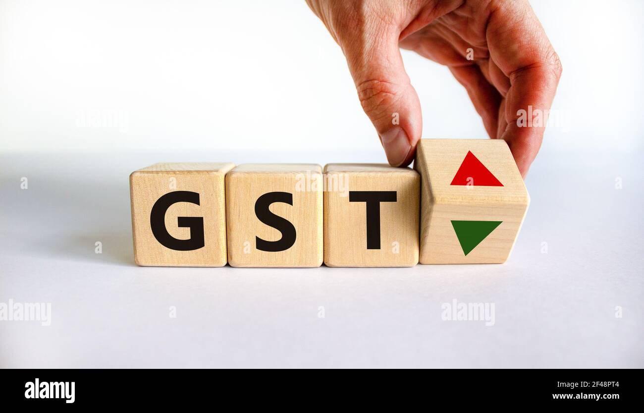 GST, goods and services tax symbol. Businessman holds a cube with up ...