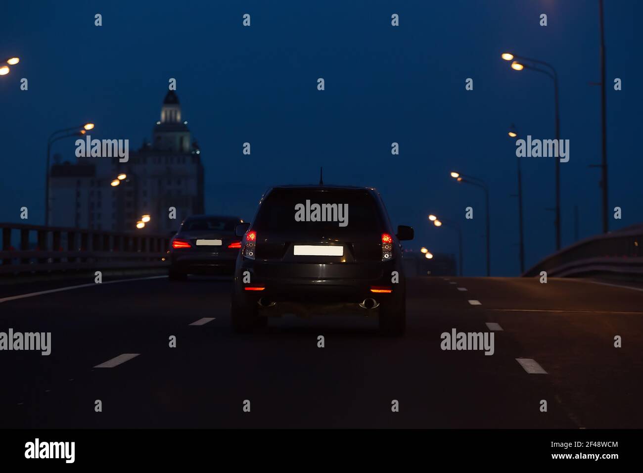 the car moves in the city on the night highway in the light of lanterns ...