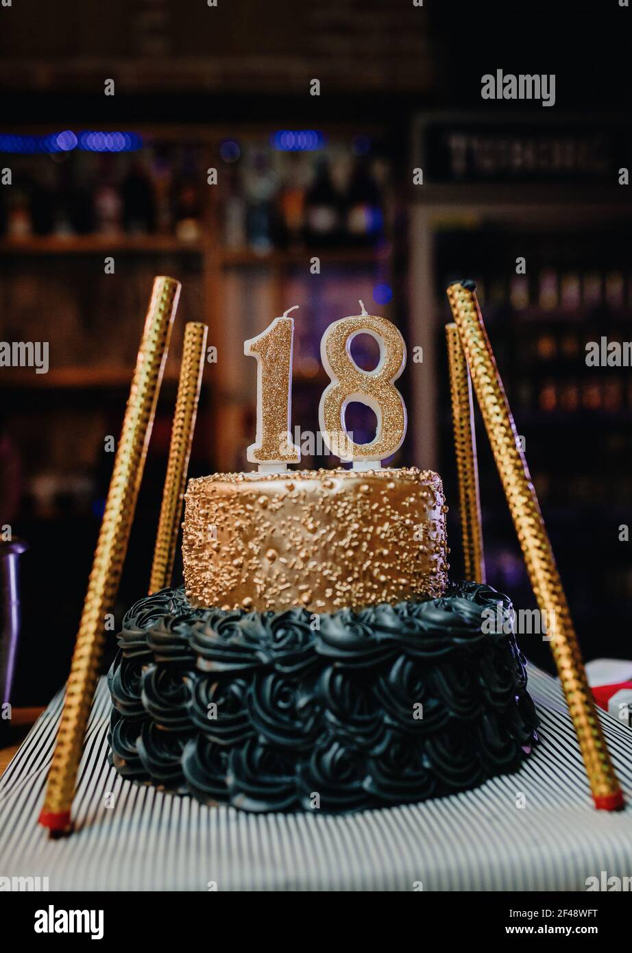 A closeup of a creamy delicious birthday cake with number 18 candles on ...