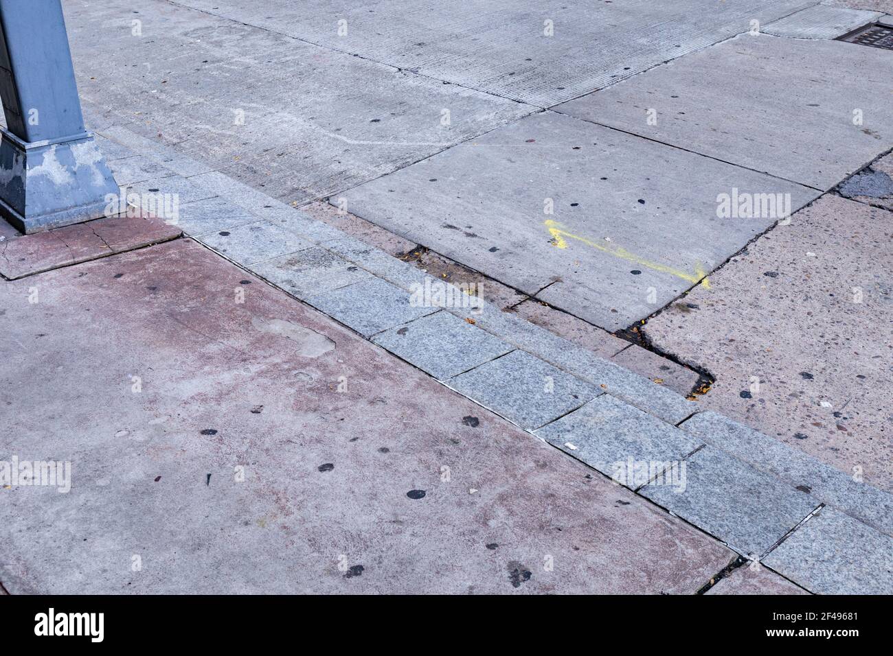 Sidewalk ramp down to street level, textures of grooved concrete and ...