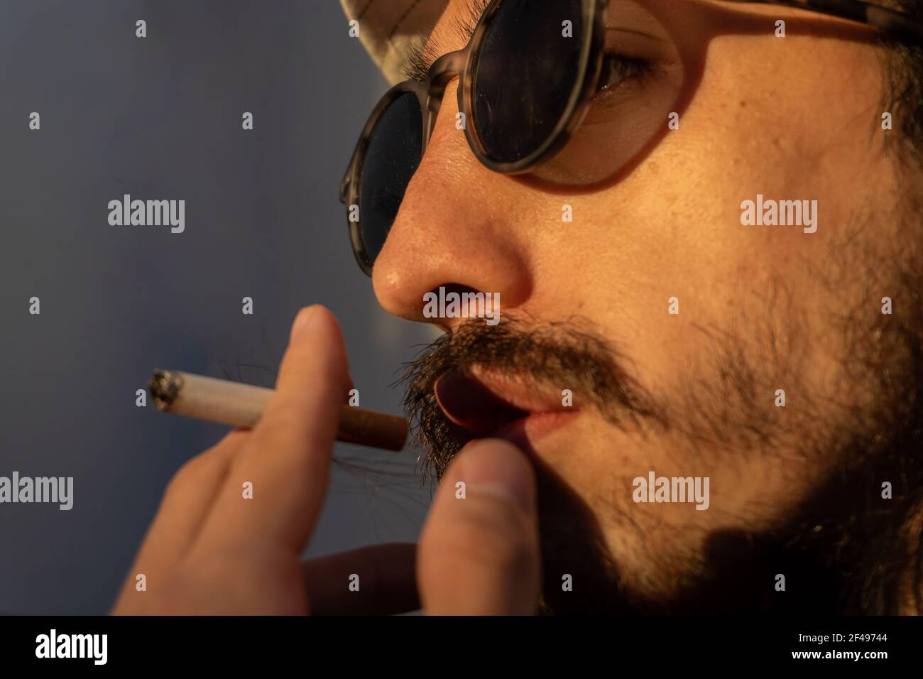 man smoking cigarette or tobacco in the sun. silhouette or shadow of a ...