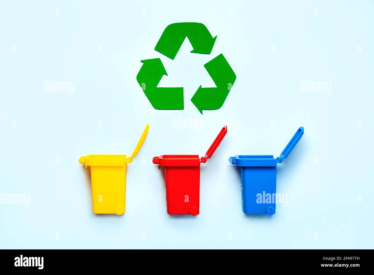 Yellow, red and blue recycle bins with recycle symbol on a blue background. Recycling concept ...