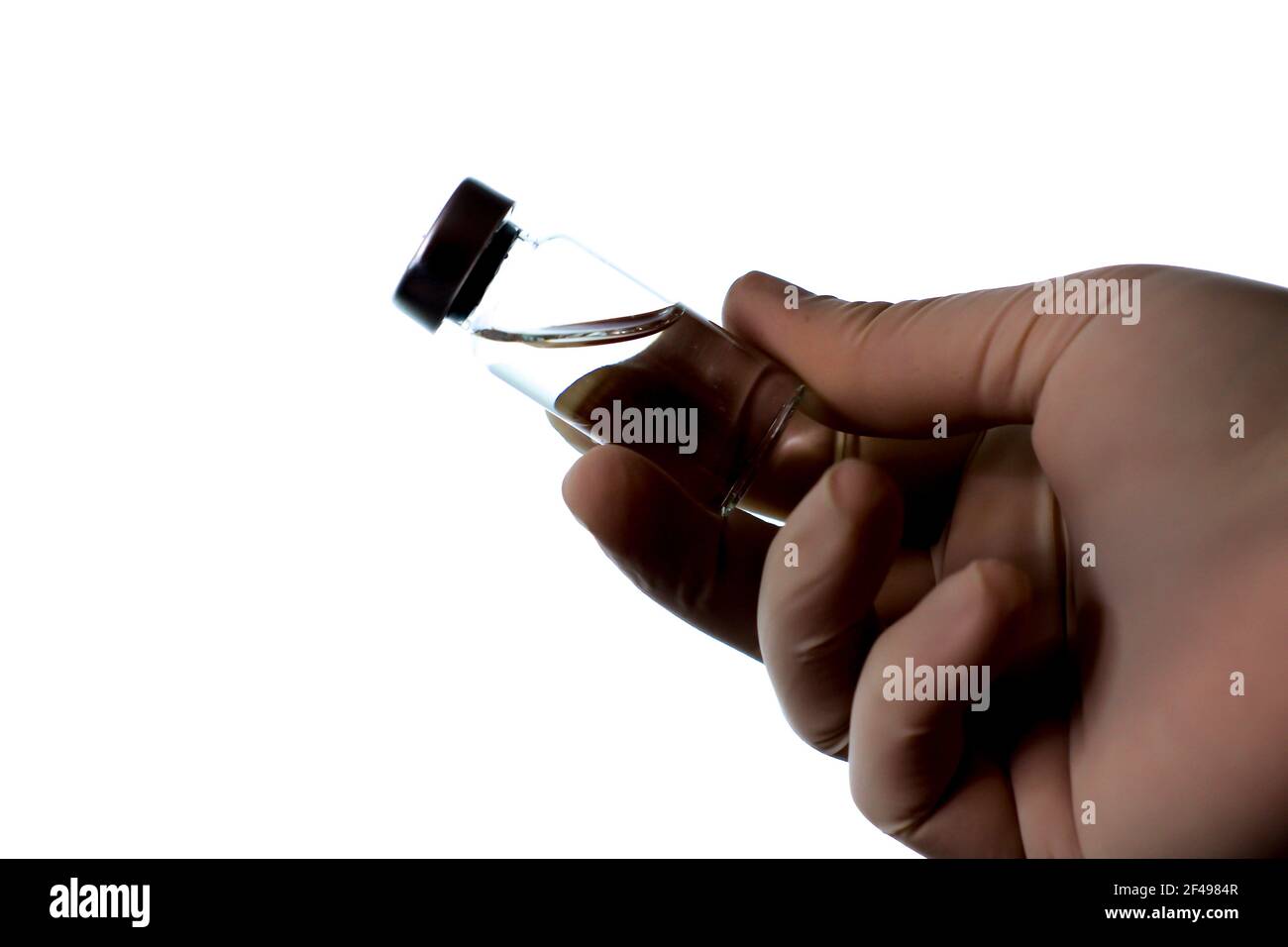 Close up picture of hand holding a vial filled with liquid on white ...