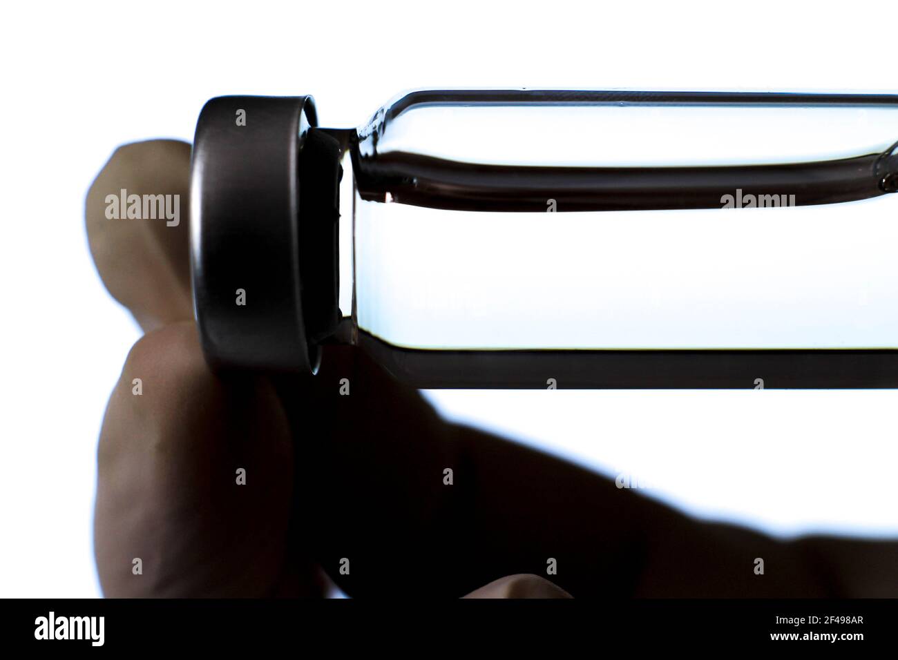 Close up picture of hand holding a vial filled with liquid on white ...