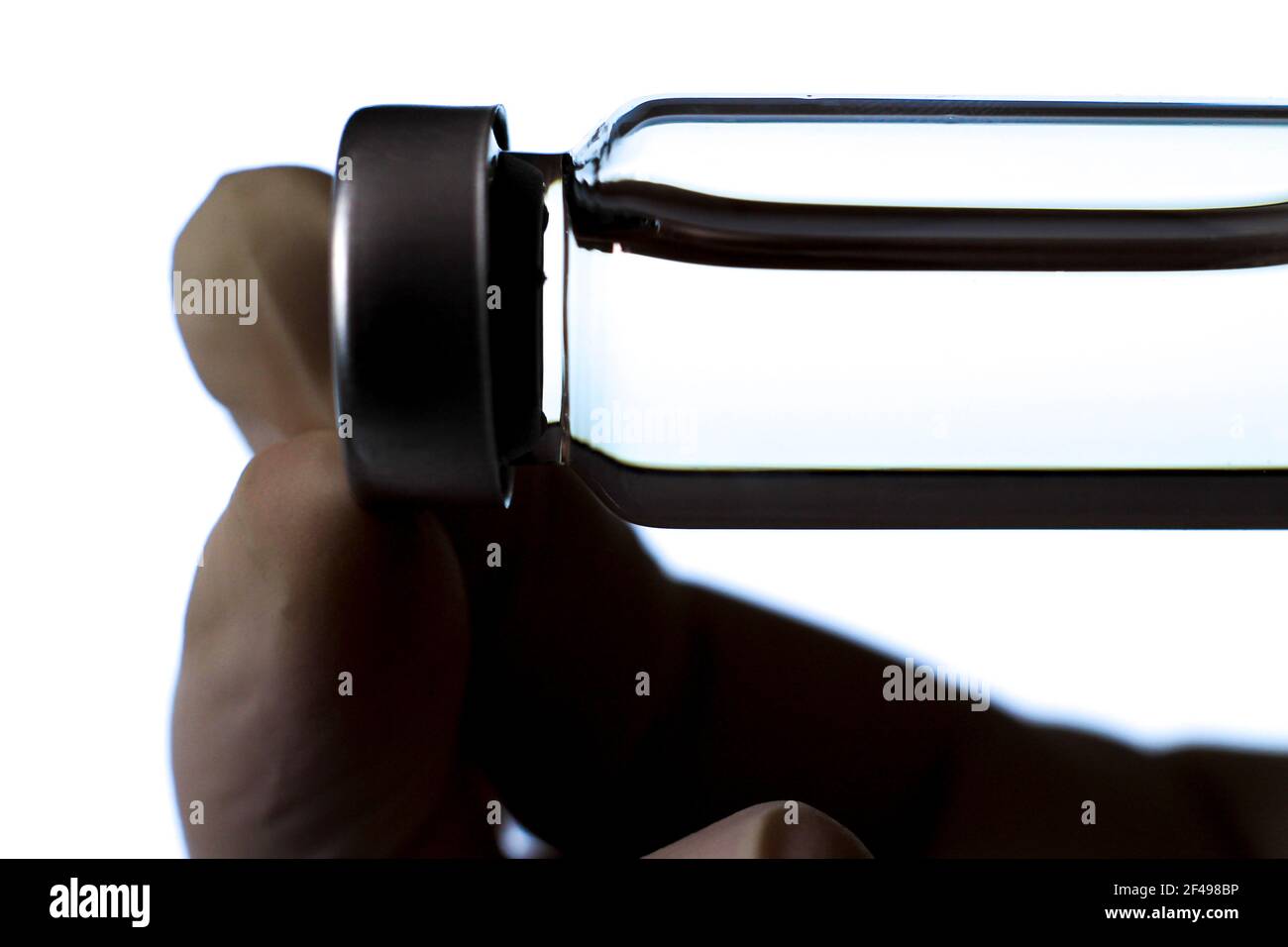 Close up picture of hand holding a vial filled with liquid on white ...