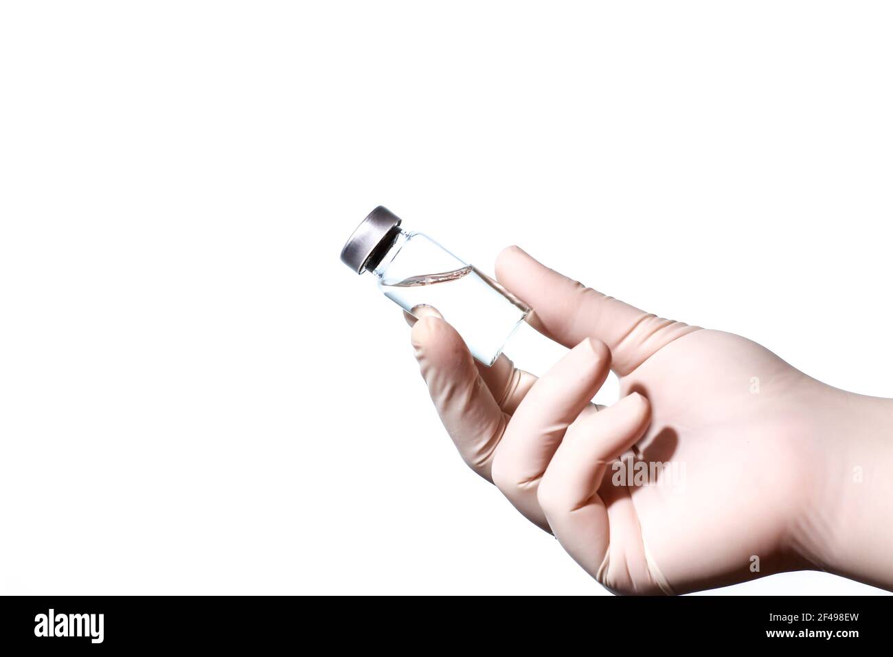 Close up picture of hand holding a vial filled with liquid on white ...