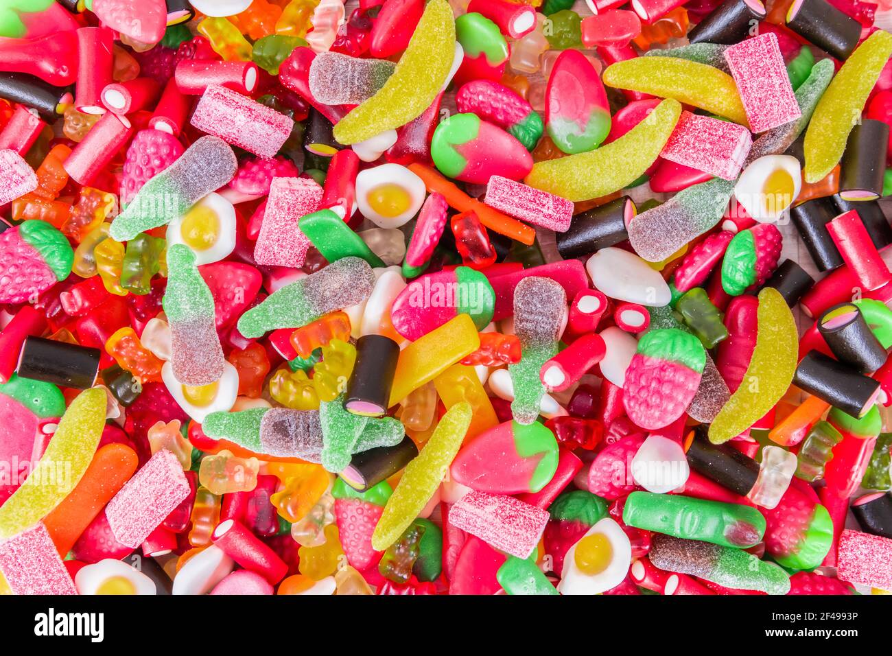 A top view of gummy candies with fruit flavor and sugar toppings under ...