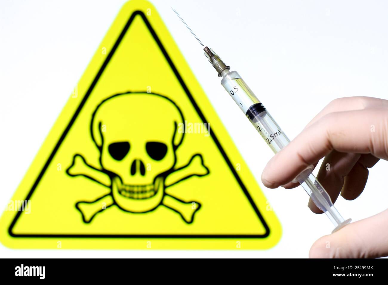 Close up picture of hand holding a syringe filled with liquid on white ...