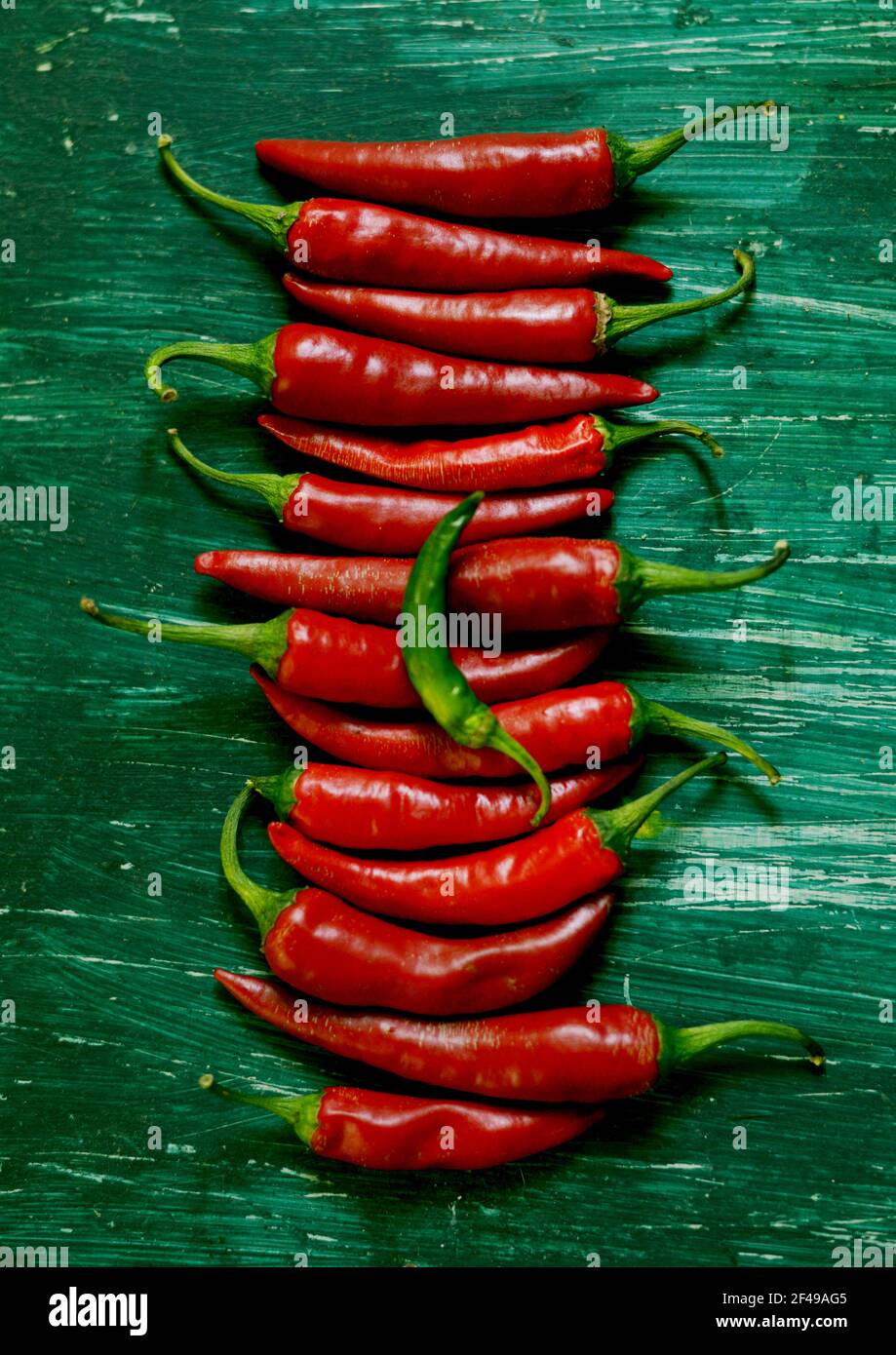 A vertical shot of spicy fresh chilis on a green background Stock Photo ...