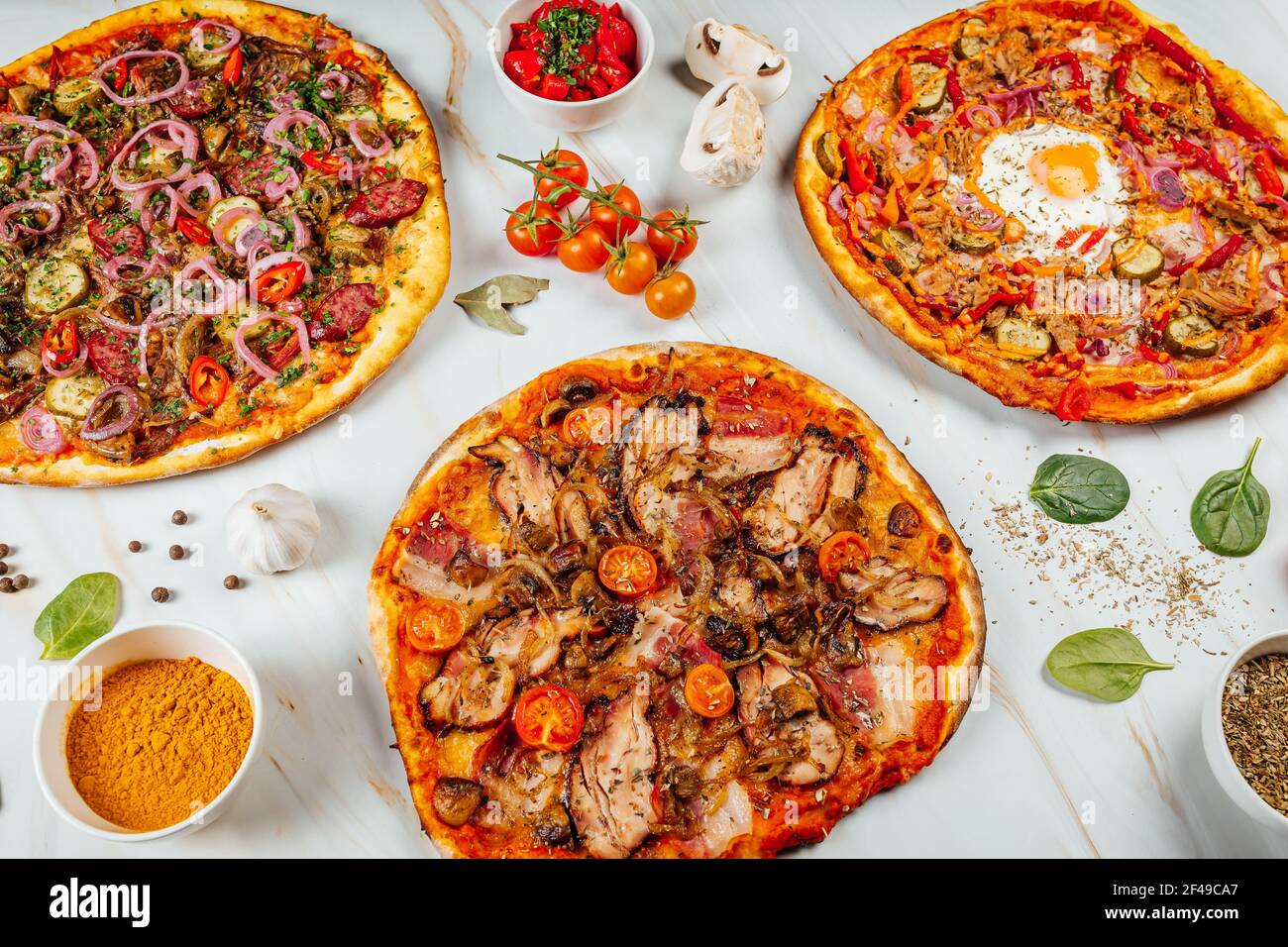 A top view of various tasty pizzas and spices Stock Photo - Alamy
