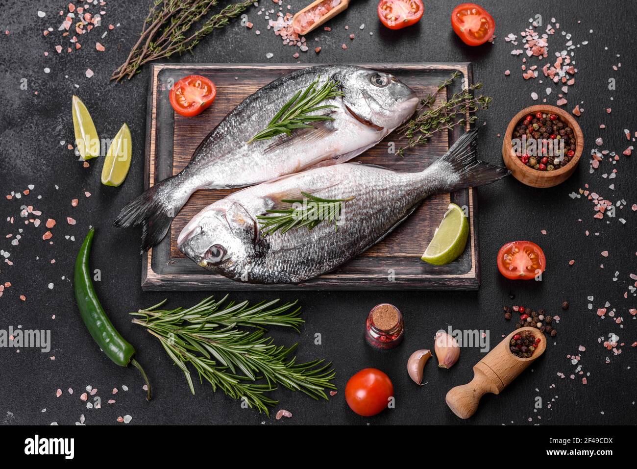 Raw dorado fish with spices cooking on cutting board. Fresh fish dorado ...