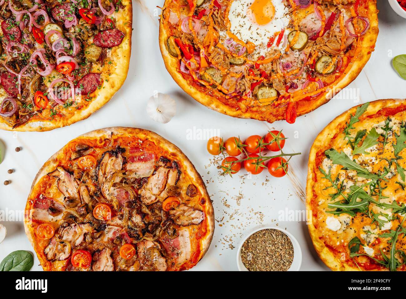 A top view of various tasty pizzas and spices Stock Photo - Alamy