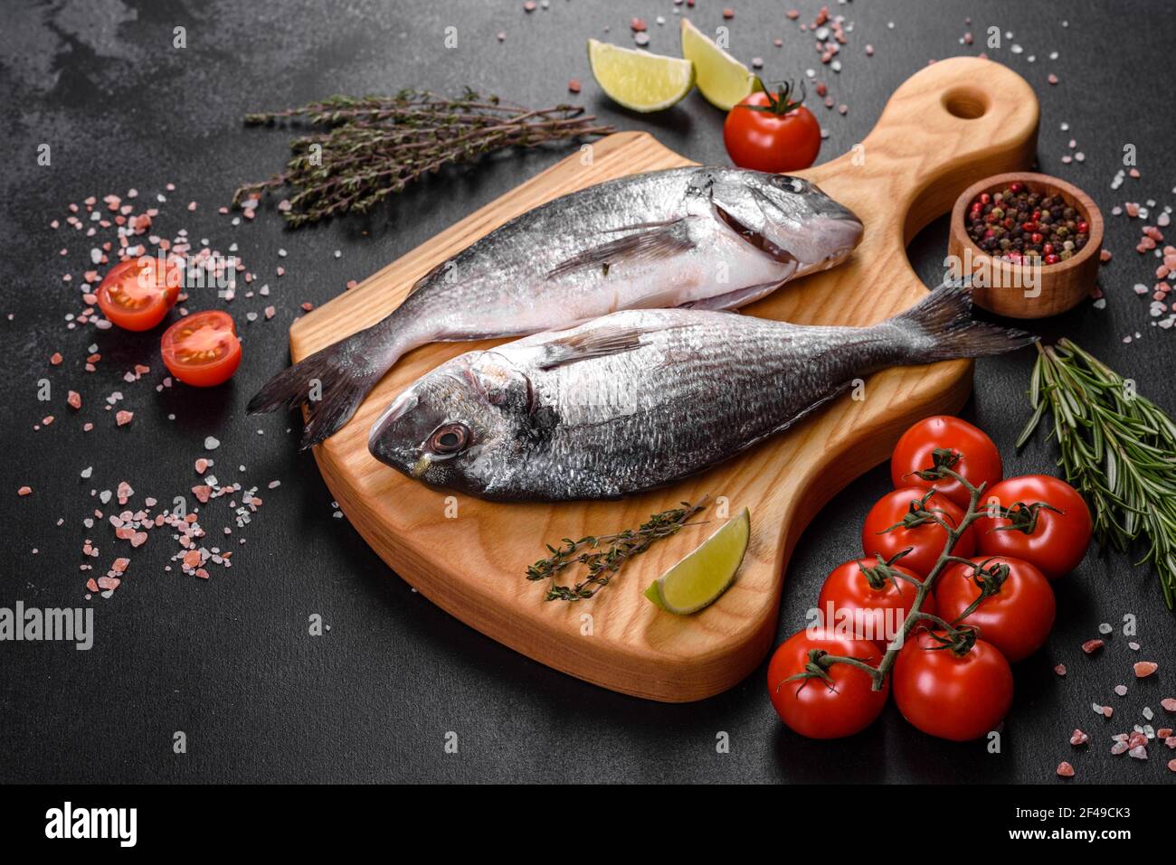 Raw dorado fish with spices cooking on cutting board. Fresh fish dorado ...