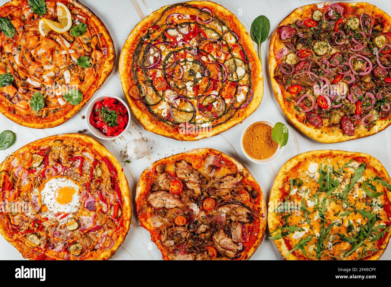 A top view of a variety of tasty pizzas with spic Stock Photo - Alamy