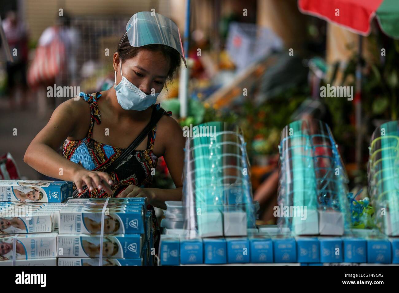 A vendor arranges boxes of face shields outside the Quiapo church ...
