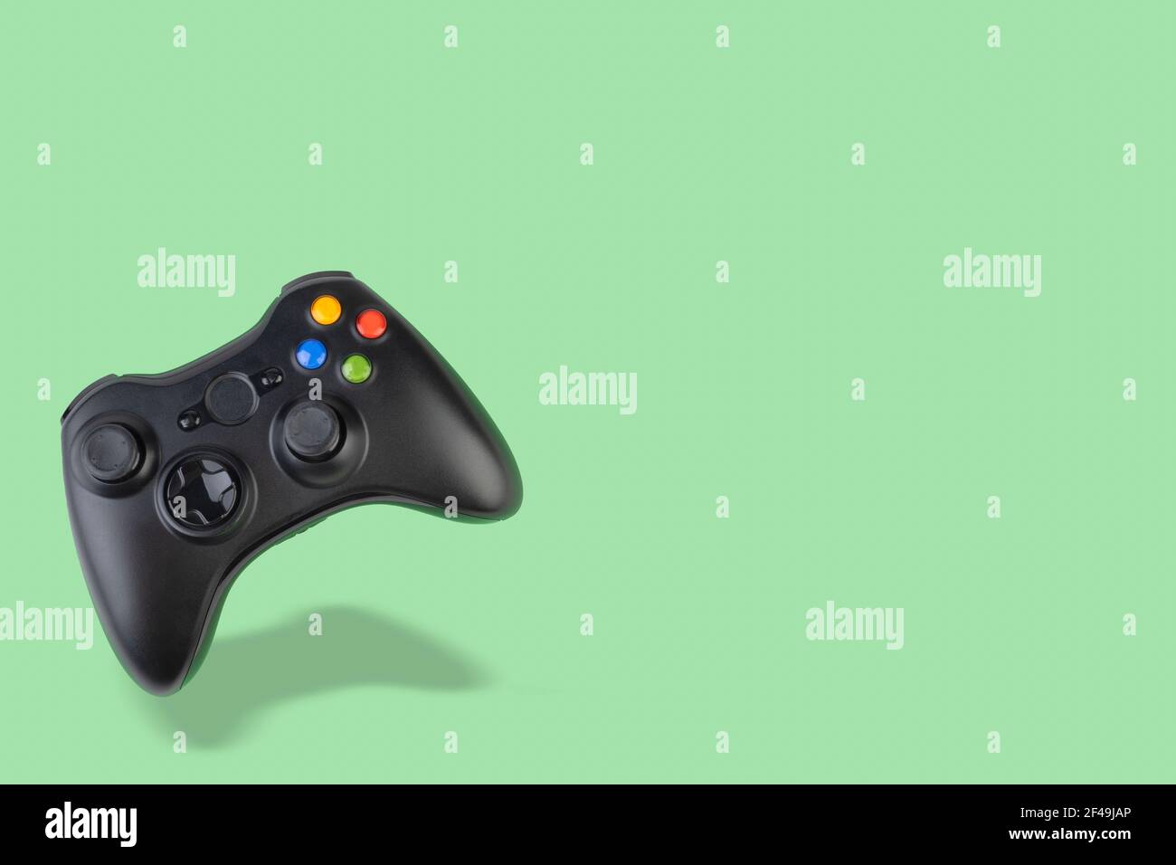 Floating videogame controller over green background with copy space ...