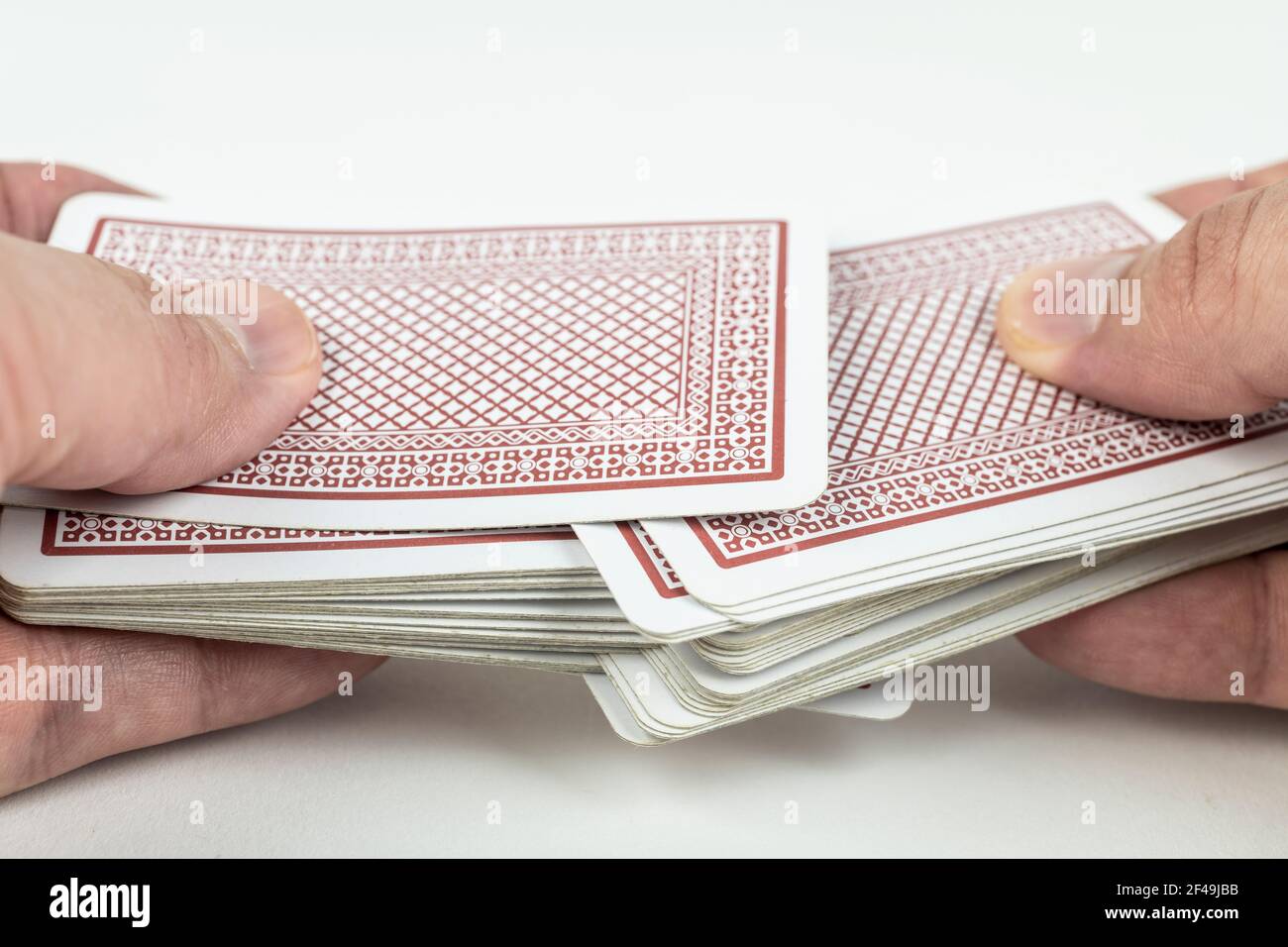 Hands shuffling playing cards on white background Stock Photo - Alamy