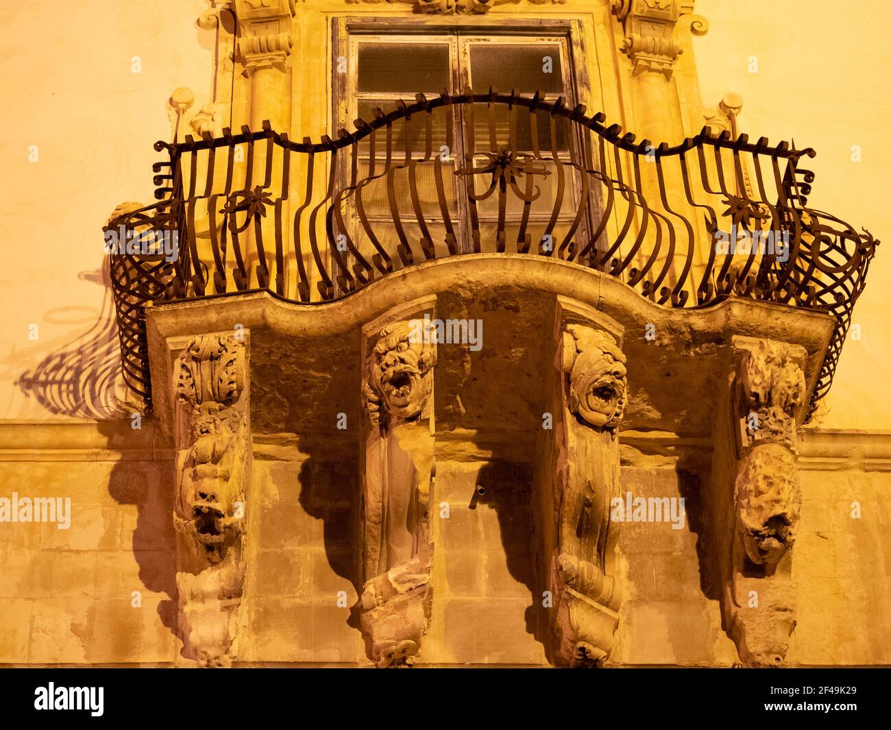 Grotesque faces with open mouth supporting a balcony of the Baroque ...