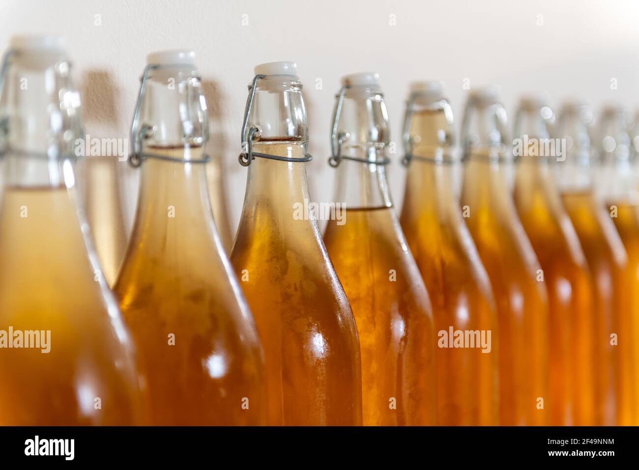 Close up of a row of flip top bottles of home made cider covered in ...