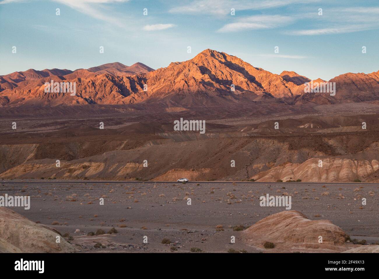 Landscape view of the mountains in Death Valley, with a car driving by ...