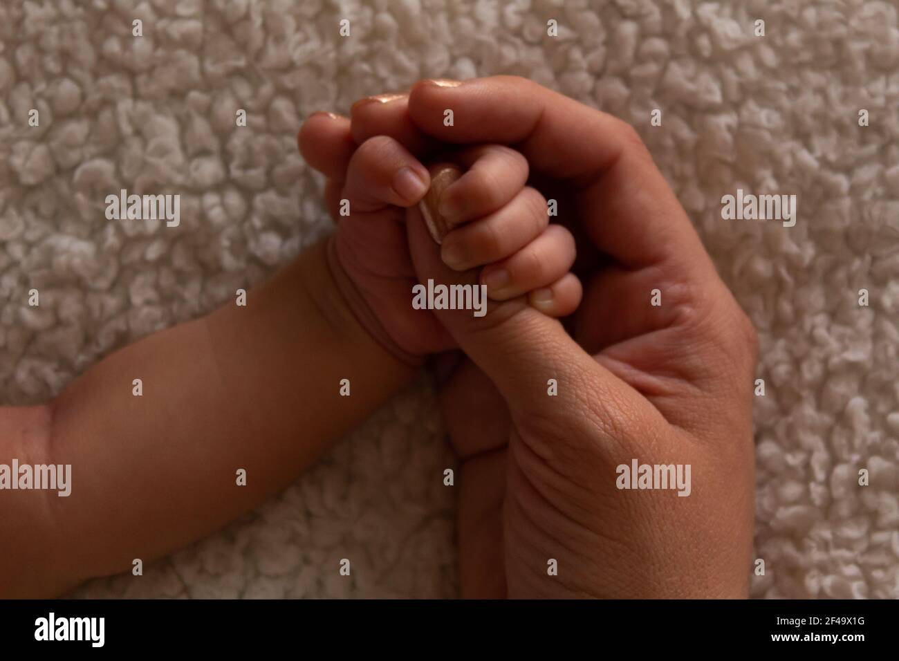 parents hands holding their baby's hand Stock Photo - Alamy