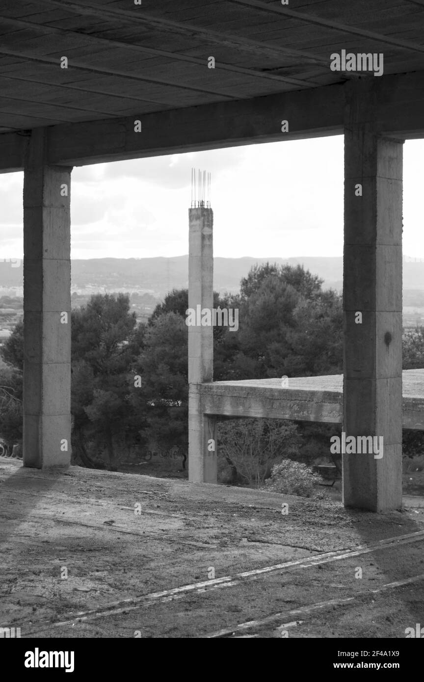 A vertical greyscale shot of concrete columns in a construction site ...