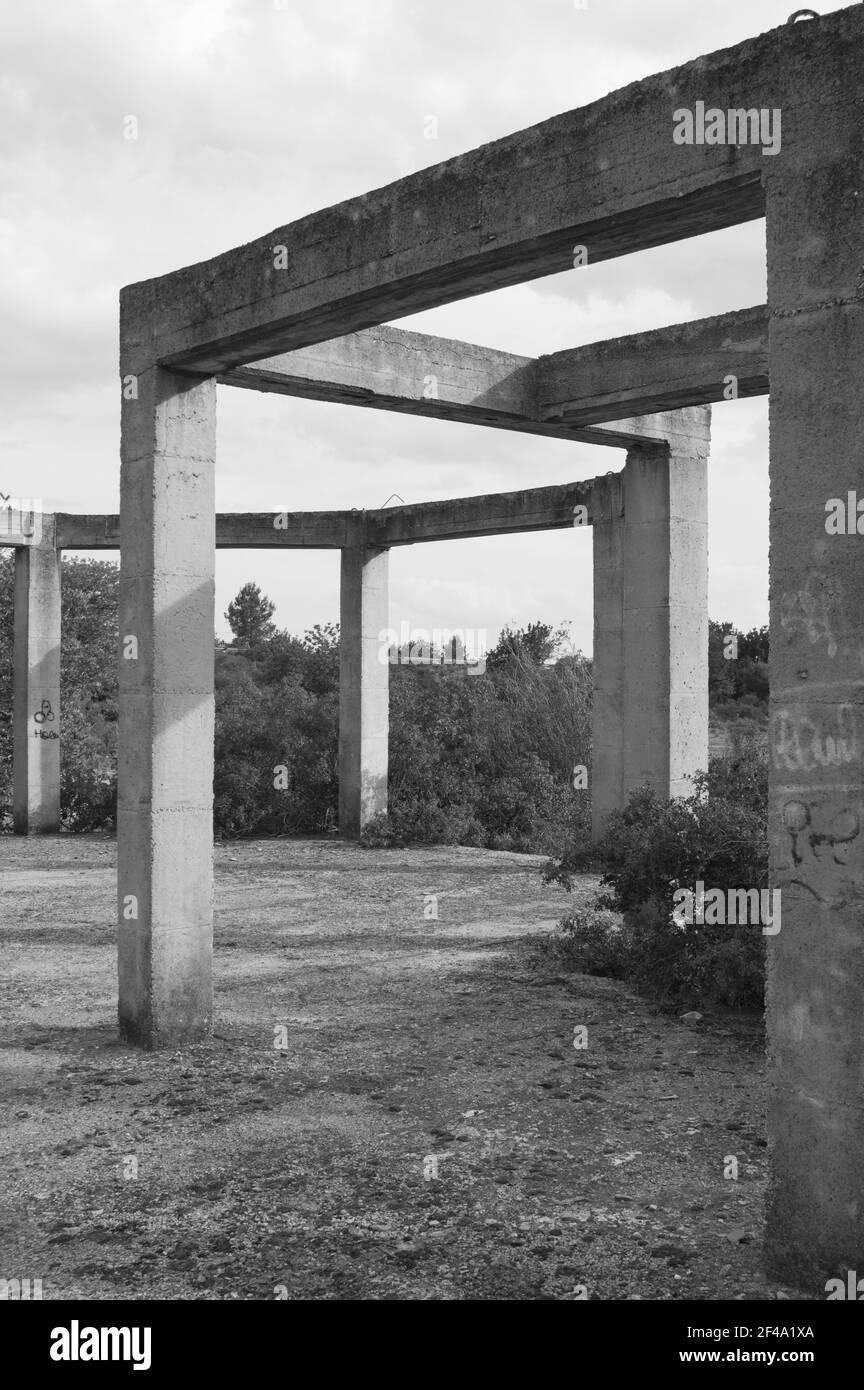 A vertical greyscale shot of concrete columns in a construction site ...