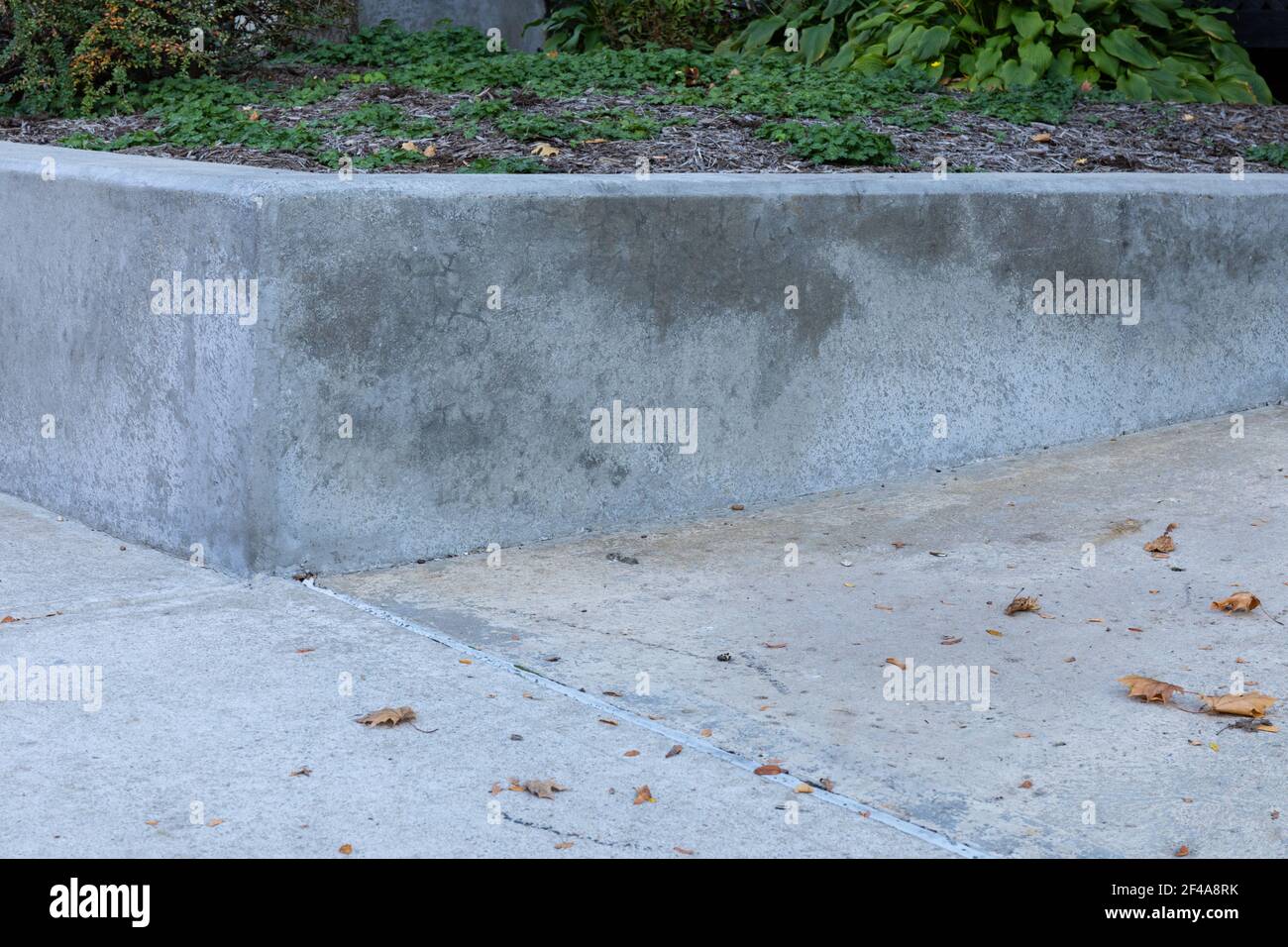 Well maintained concrete retaining wall at a corner bordered by ...