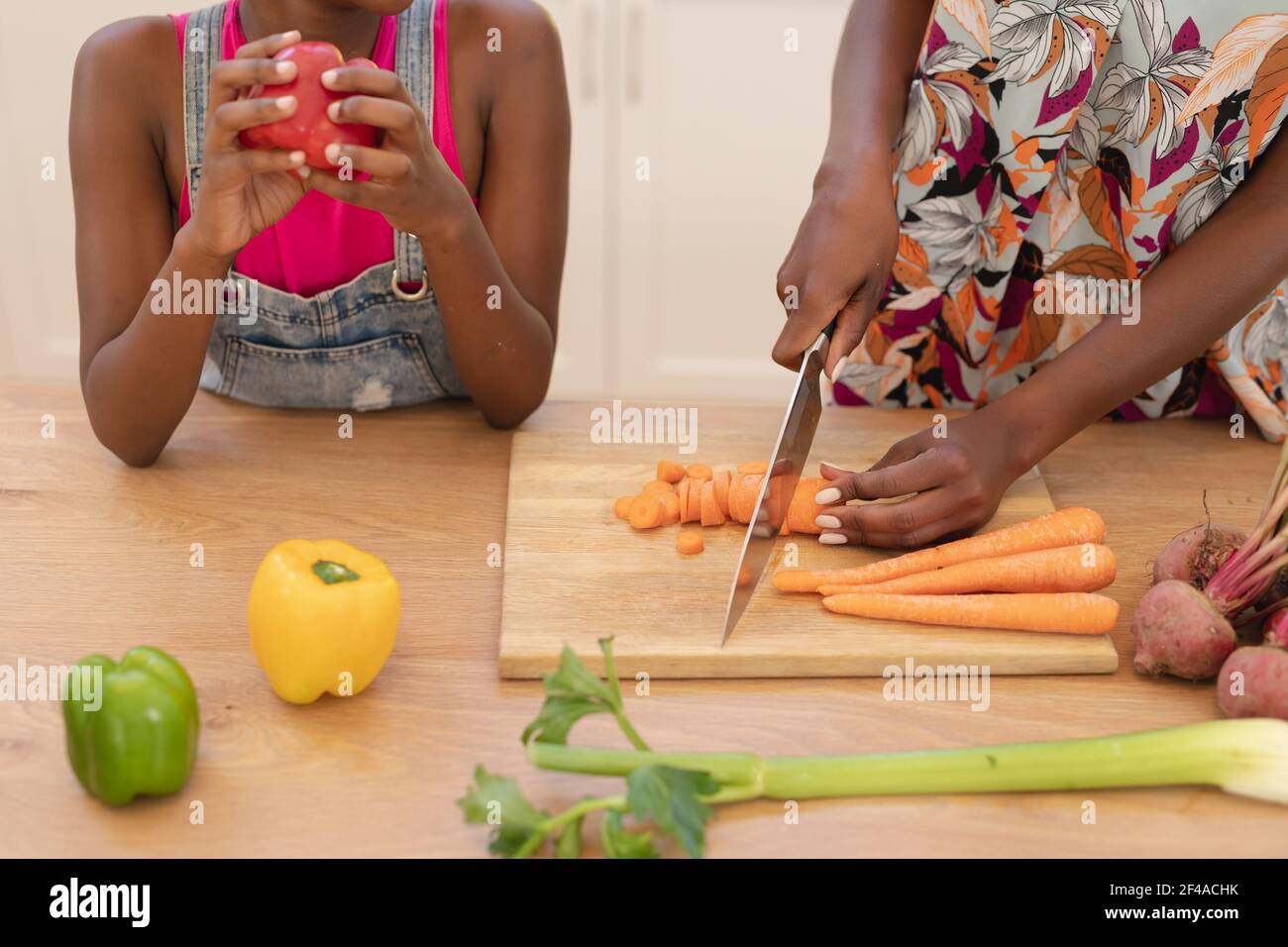 African american mother teaching daughter cooking in the kitchen Stock ...