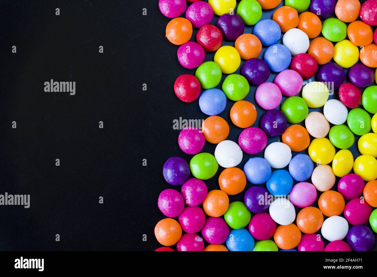 A closeup shot of colorful sweet candies isolated on a dark background ...