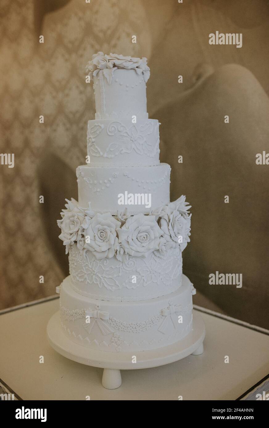 A multi-story white wedding cake decorated with white flowers Stock ...
