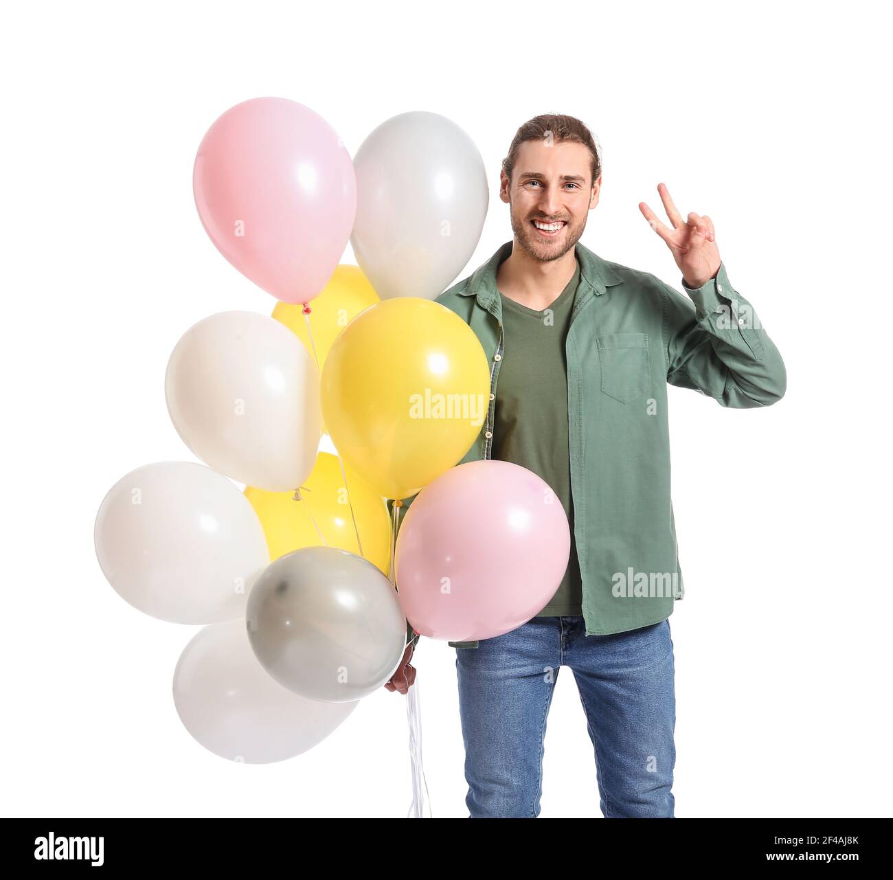 Handsome young man with balloons showing victory gesture on white ...