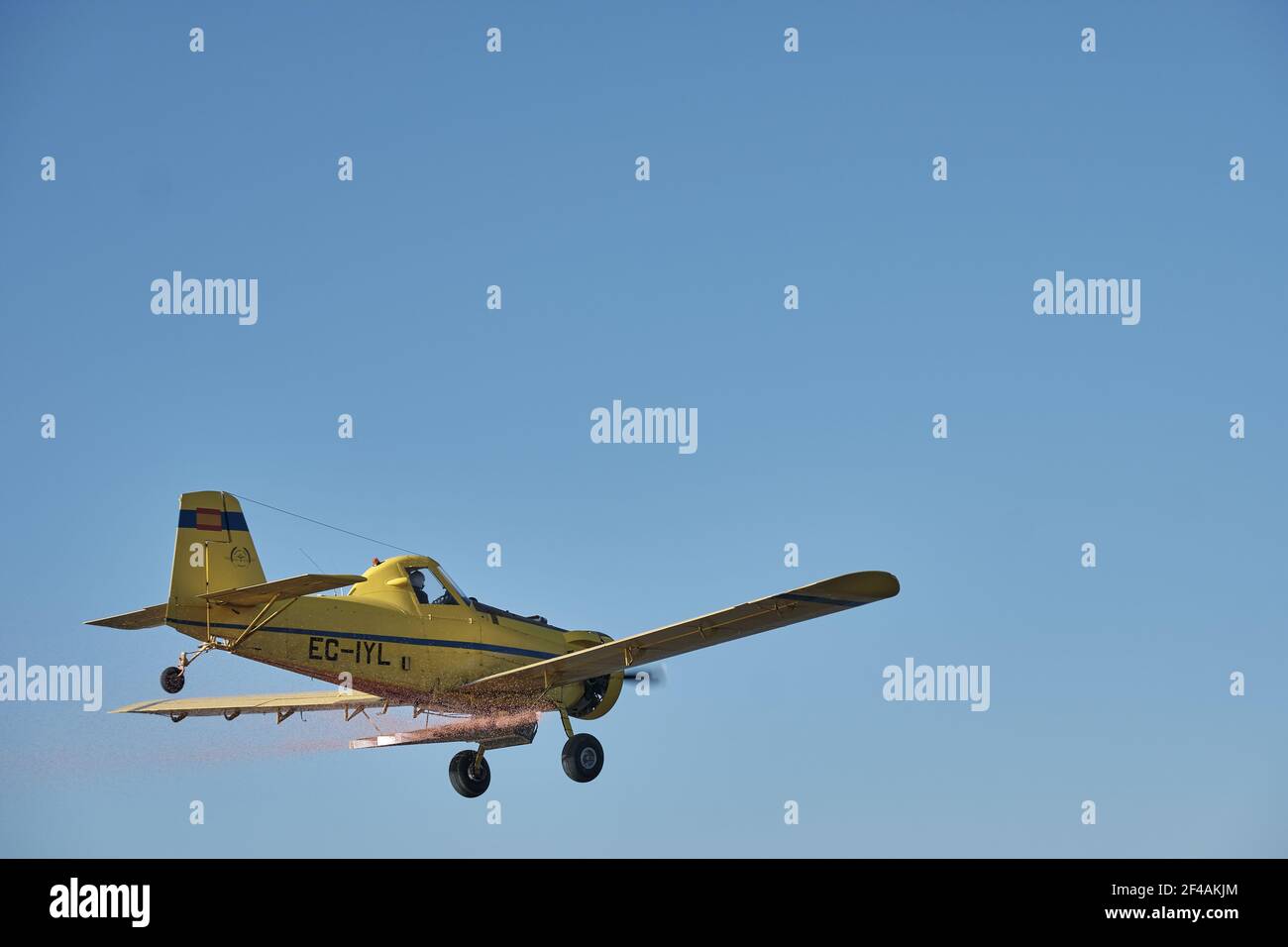 A single-engine propeller airplane flying in a perfectly clear blue sky ...