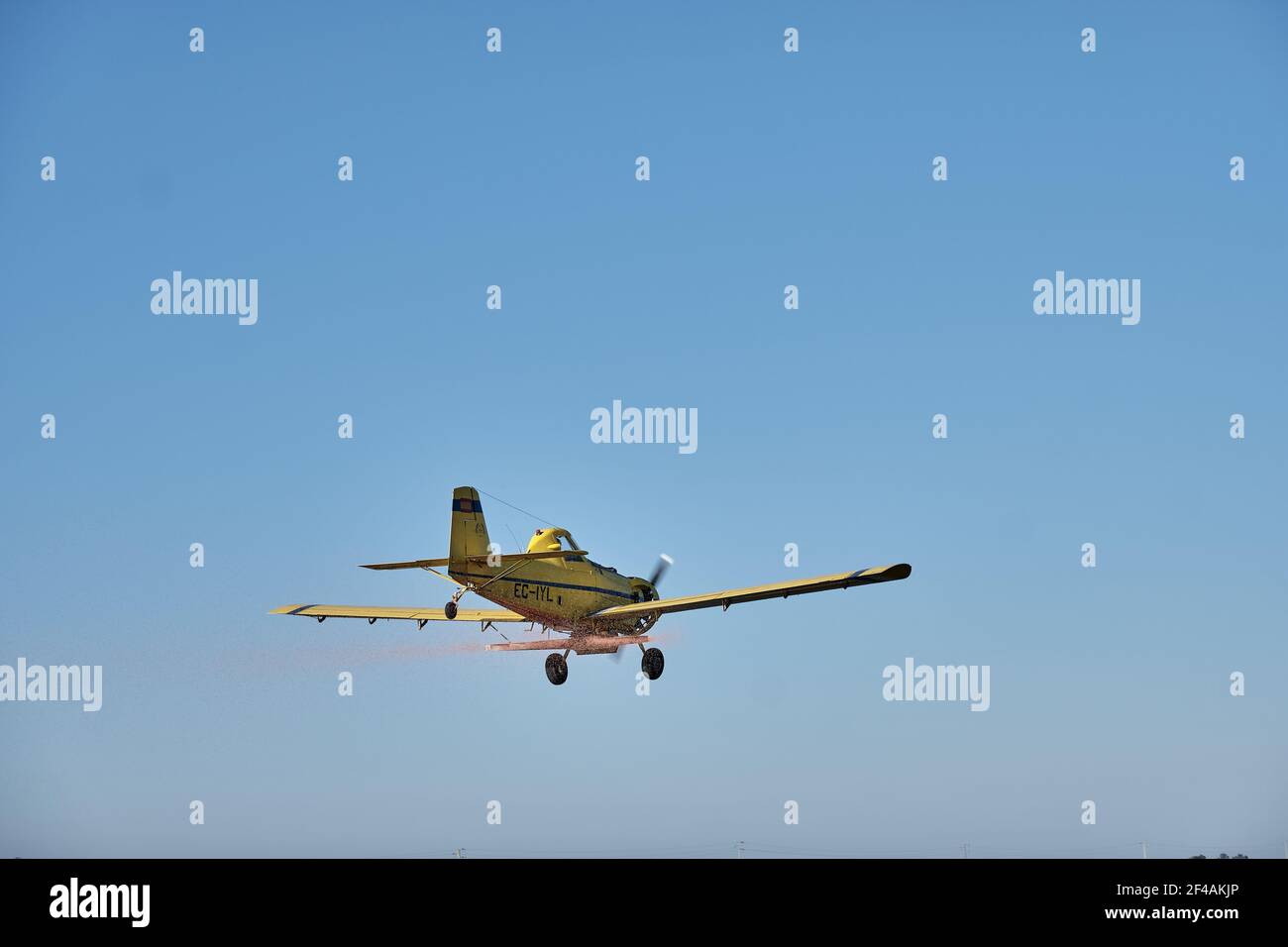 A single-engine propeller airplane flying in a perfectly clear blue sky ...