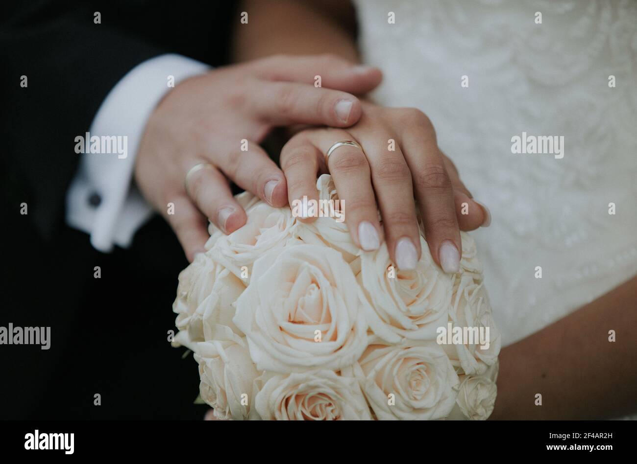 A closeup of bride and groom hands on the soft bridal bouquet Stock ...